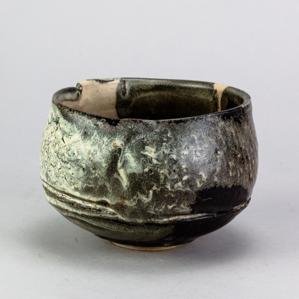 CLAUDE CHAMPY (born 1944); a stoneware chawan covered in black, grey ...